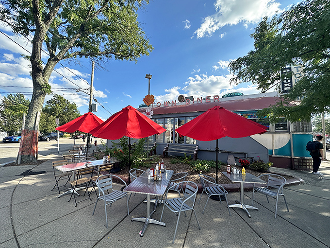 Red umbrellas and outdoor tables create a sidewalk oasis where pancake dreams come true under Massachusetts skies.