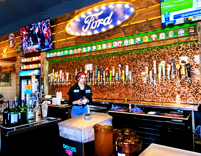 Behind that penny-topped bar, craft beers flow from gas pump taps while the illuminated Ford sign reminds you this isn't your average watering hole.