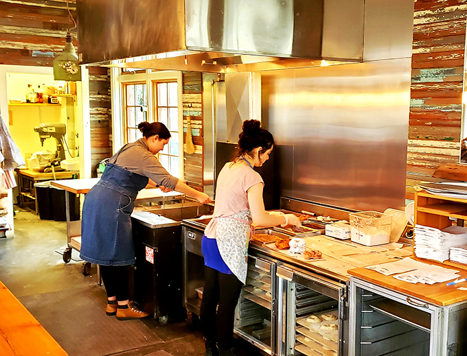 The doughnut whisperers at work! These skilled artisans are the unsung heroes of your breakfast bliss. It's like watching Michelangelo sculpt, but with dough instead of marble.
