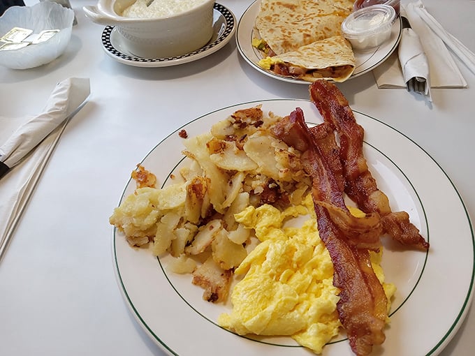 The holy trinity of breakfast: golden eggs, crispy bacon, and hash browns that have achieved that perfect crisp-to-tender ratio.