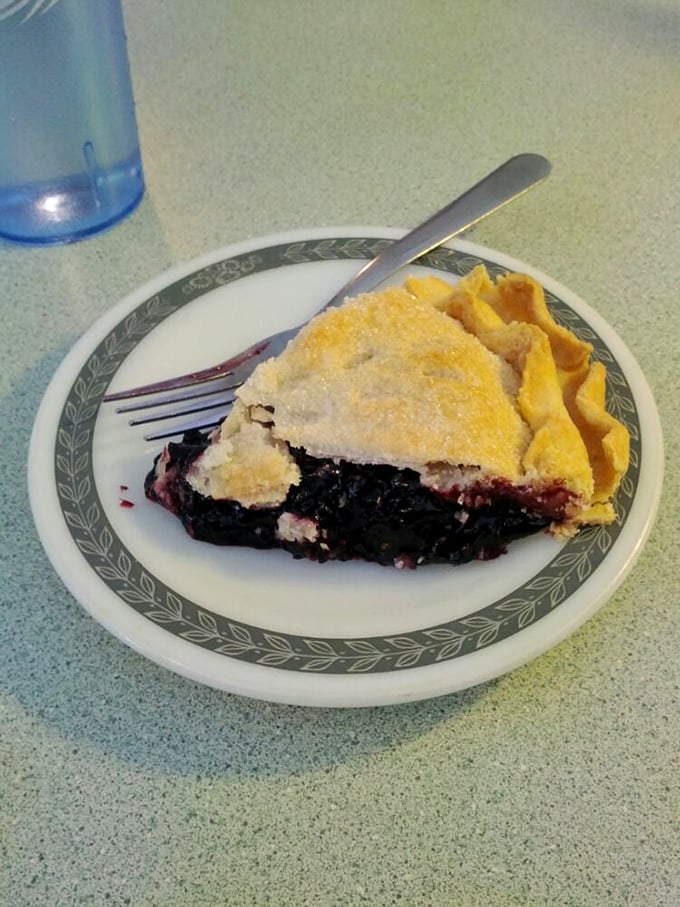 A slice of black raspberry pie that makes you understand why people used to cool pies on windowsills despite the risk of theft. Worth climbing a trellis for.