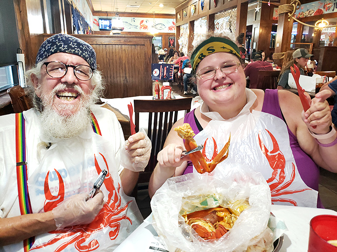 Seafood warriors in action! These happy diners, armed with crab-cracking tools and bibs, are ready for a delicious battle.