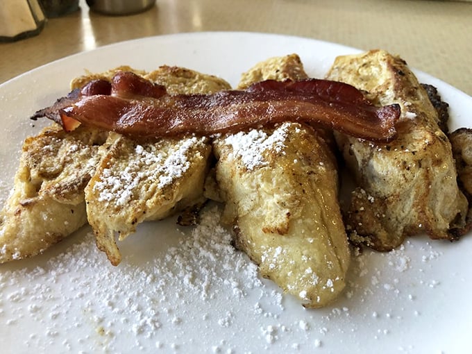French toast that could make a baguette jealous. Dusted with powdered sugar and crowned with bacon, it's the royal treatment for your taste buds.