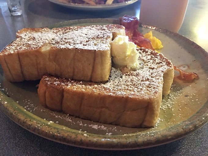 French toast that could make a Parisian weep with joy, dusted with powdered sugar like the first perfect snowfall of winter.