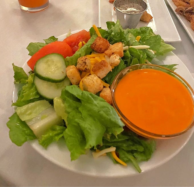 A house salad that didn't get the memo about being boring, dressed in a vibrant orange dressing that means business.