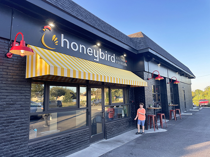 Evening light bathes the black exterior in golden warmth. The yellow awning practically winks at you: "Yes, this is the place."