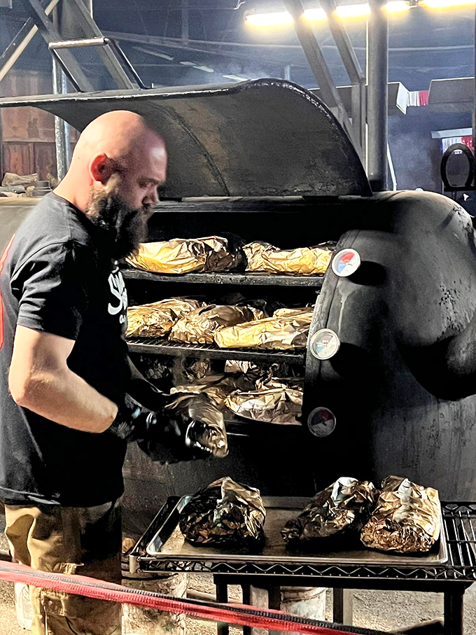 Smoke signals never looked so delicious. This pit master's tending to his flock of foil-wrapped flavor bombs with religious devotion.
