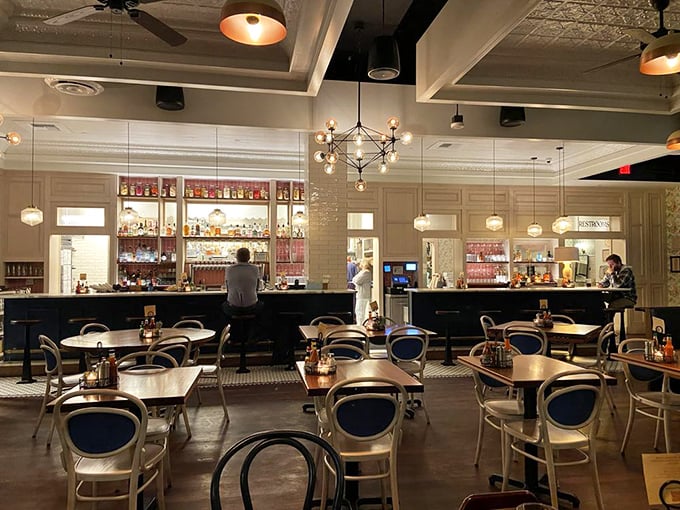 The bar area gleams with promise, bottles standing at attention like soldiers ready to serve in the cocktail wars.