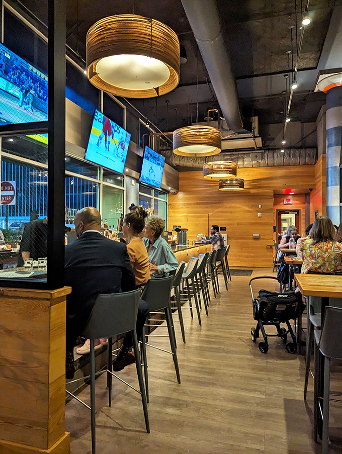 The bar area hums with the energy of people making good life choices. Those drum-shaped pendant lights add the perfect touch of "I've arrived somewhere special."