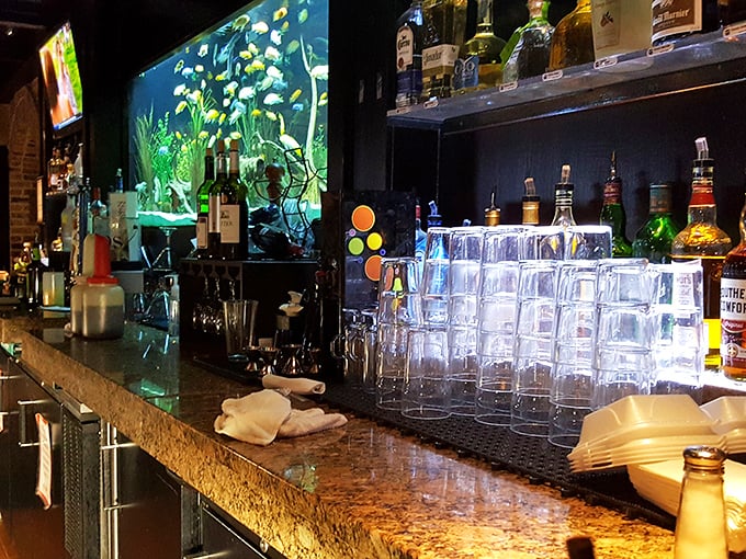 The bar area gleams with promise, where fish tanks meet cocktail crafting in an unexpectedly delightful pairing.