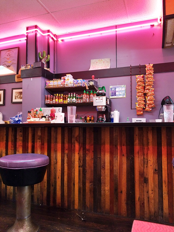That pink neon glow over wooden paneling isn't Instagram lighting&mdash;it's the authentic aura of a place that's witnessed countless conversations.
