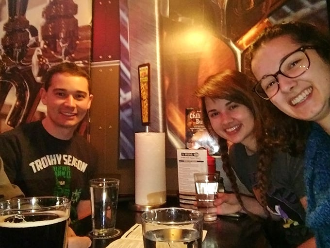 The image shows people enjoying food and drinks at a restaurant table.