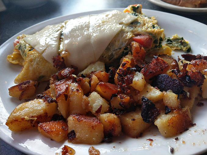 Omelet, oh yes! Paired with home fries crispier than a Florida retiree's tan. This plate is a morning masterpiece worthy of the Louvre.