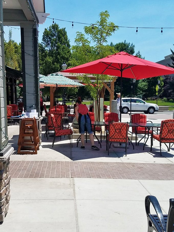Red umbrellas stand guard over outdoor tables, creating an oasis where breakfast and fresh air perform a delicious duet.