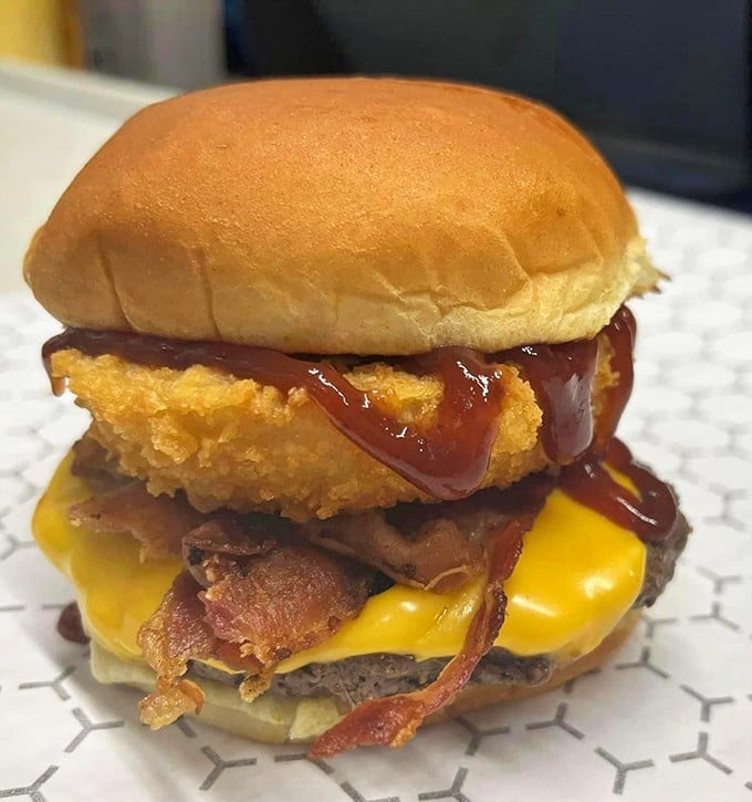 Ladies and gentlemen, meet the heavyweight champion of burgers. This bacon cheeseburger isn't just a meal; it's a dare. Are you up for the challenge?