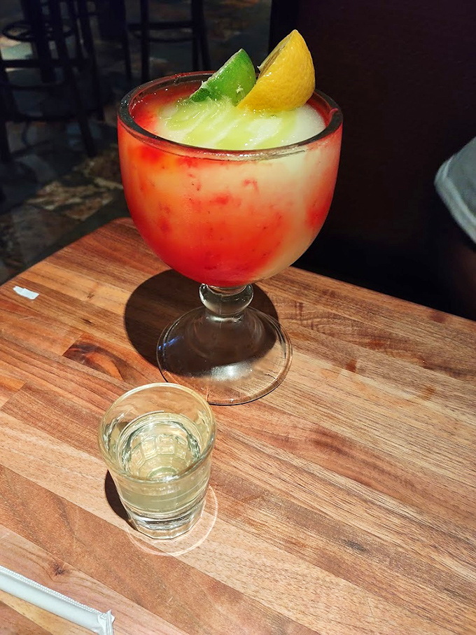 This colorful cocktail, garnished with citrus, isn't just a drink—it's a vacation in a glass. The shot on the side suggests things might get interesting.