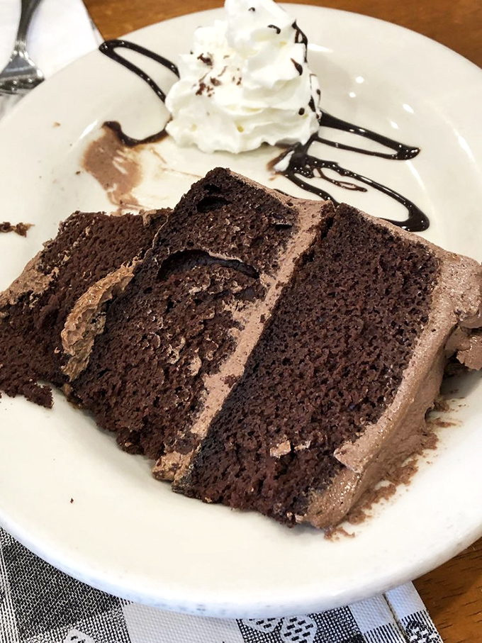 Chocolate cake so rich it should have its own tax bracket, topped with a dollop of whipped cream for good measure.