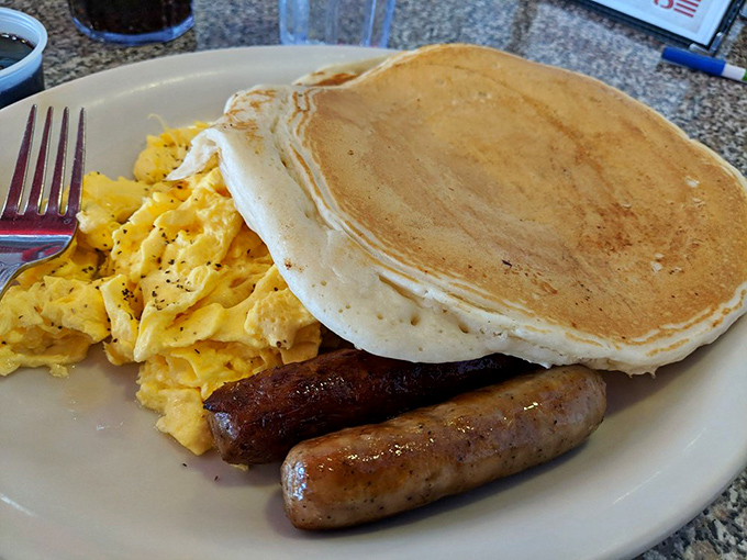 A breakfast platter that could double as a life raft. Fluffy pancakes, sausage links, and eggs &ndash; oh my!