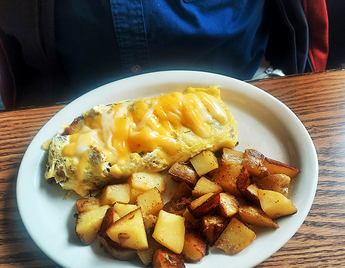 Behold, the omelet in its natural habitat: surrounded by crispy potatoes and ready to make your taste buds do a happy dance.