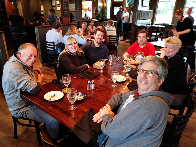Happy diners gathered around a wooden table – the universal sign that you've found a place worth sharing with friends and making memories.