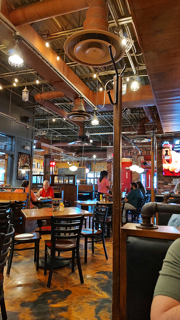 Industrial pipes overhead and warm lighting create the perfect backdrop for conversations that last longer than the food on your plate.
