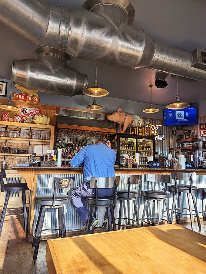 The bar's corrugated metal backdrop and exposed ductwork create that perfect "discovered gem" atmosphere. Every stool promises a front-row seat to flavor town.