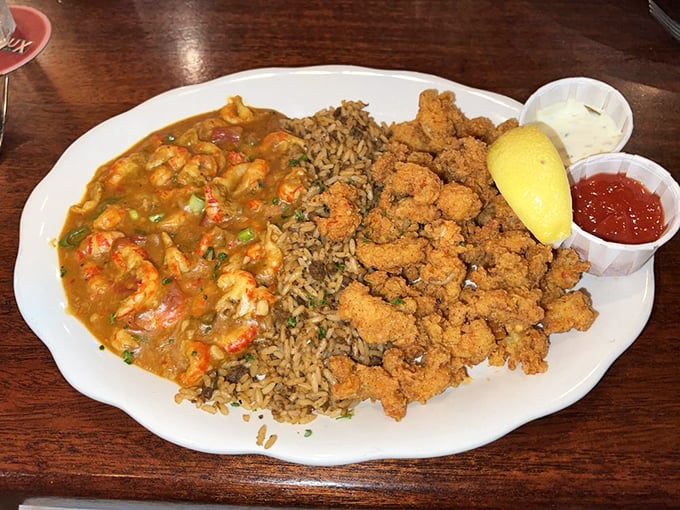 The holy trinity of Cajun cuisine: crawfish, dirty rice, and crispy goodness. This plate's got more layers than a New Orleans jazz riff.