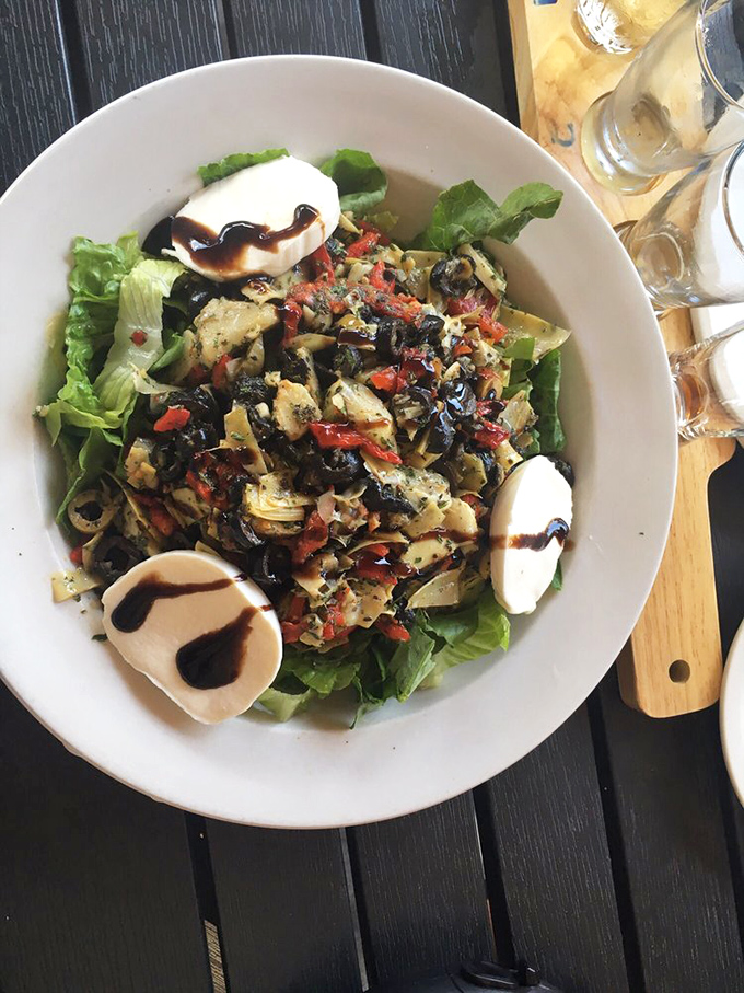A salad that doesn't apologize for its existence, boldly featuring marinated vegetables, fresh greens, and a balsamic drizzle of perfection.