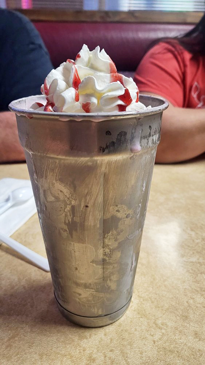 Shake it up, baby! This towering milkshake is like a skyscraper of sweetness, topped with a whipped cream penthouse.