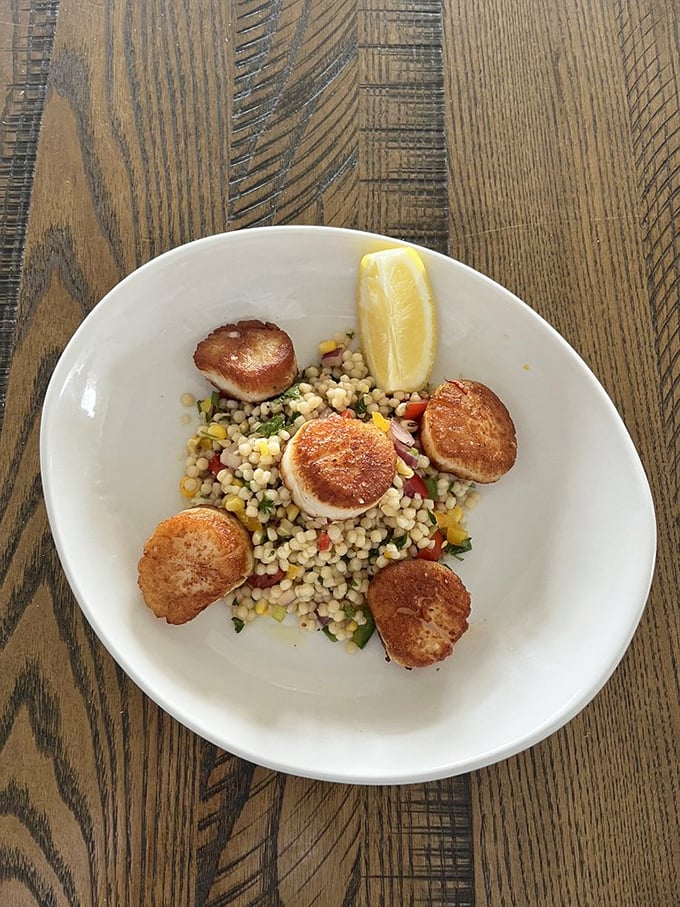 Scallops so perfectly seared, they could win a golden tan competition. Nestled on a bed of colorful veggies, it's a plate that screams "vacation mode: activated!"