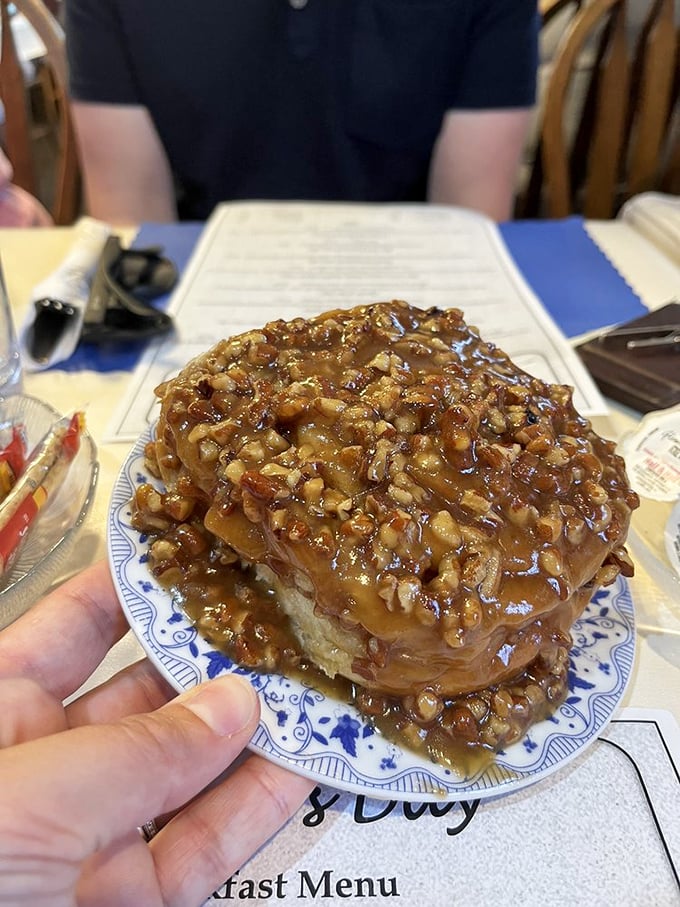 A sticky, gooey pecan-covered masterpiece that requires both napkins and willpower. One bite and you'll understand the hype.