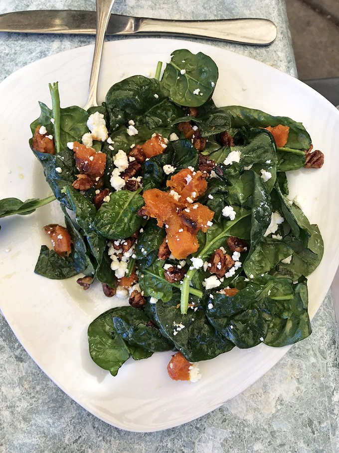 A spinach salad that doesn't apologize for being healthy. Those pecans and cheese crumbles are playing the supporting roles in nature's perfect dish.