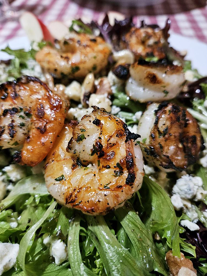 Sea meets land in this mouthwatering masterpiece! Succulent shrimp nestled on a bed of greens &ndash; it's like a garden party, but fancier.