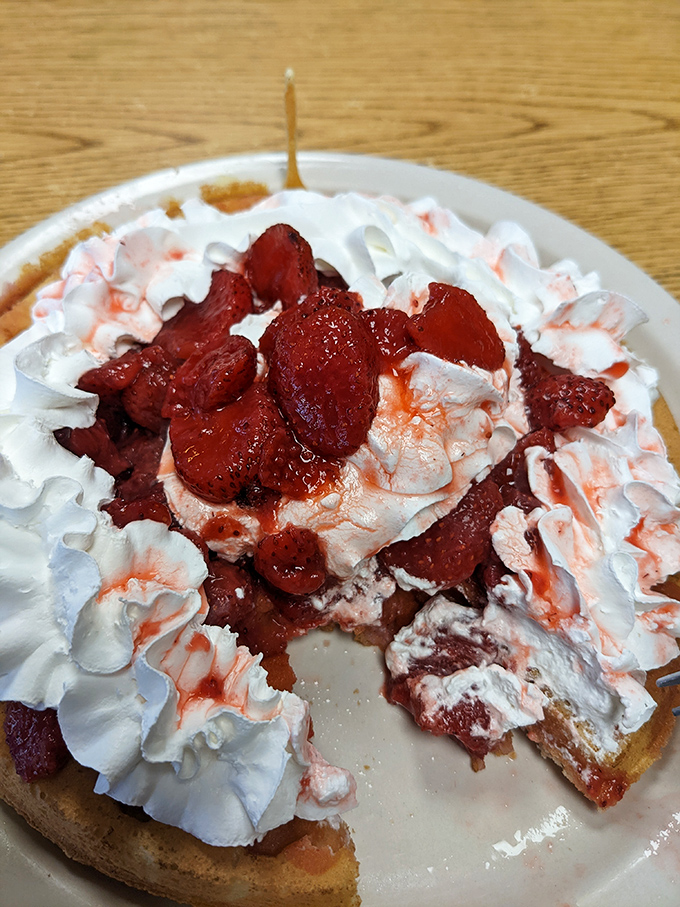 Behold the waffle of your dreams! Crowned with a ruby tiara of strawberries and a cloud of whipped cream fit for royalty.