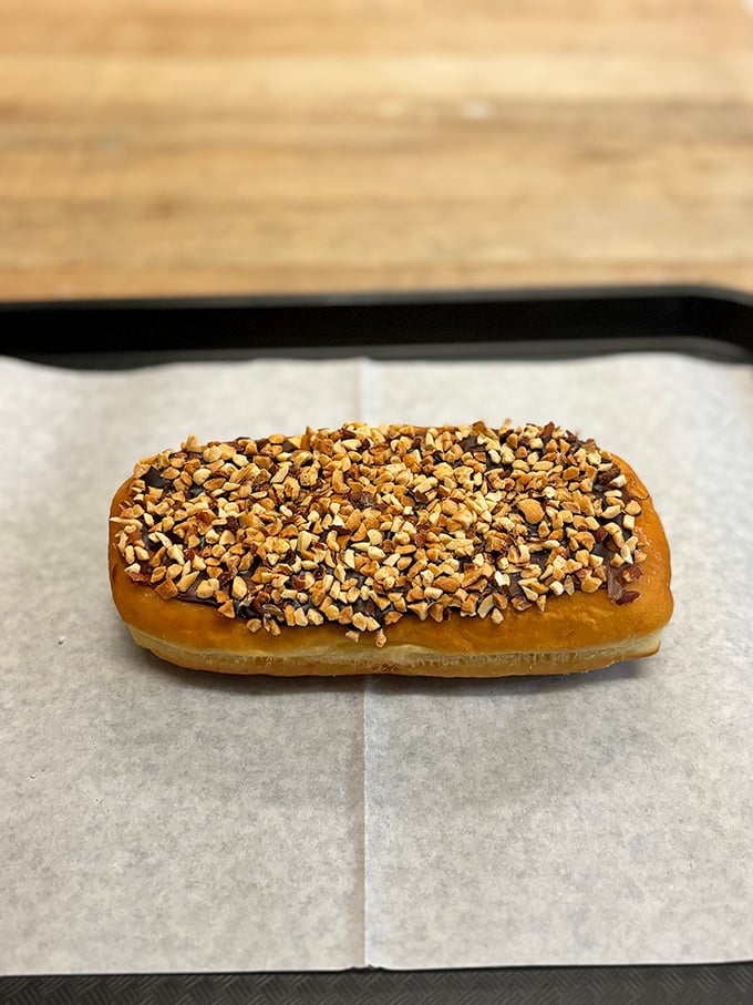 Nutty nirvana on a bun! This long john is the Cadillac of donuts, cruising down Delicious Avenue with style.