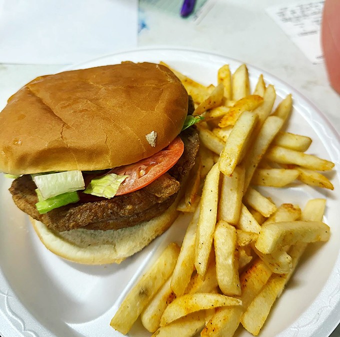 This isn't just a sandwich; it's a pork chop's crowning achievement, nestled between two pillowy buns.