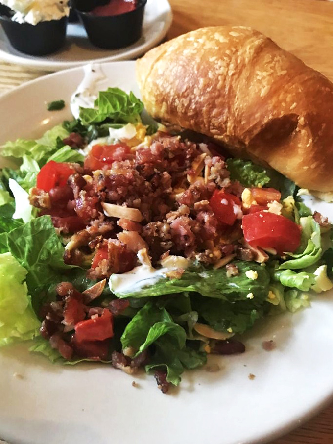 This salad brings unexpected joy with its bacon-laden personality and honey-butter croissant companion &ndash; not all heroes wear kale.