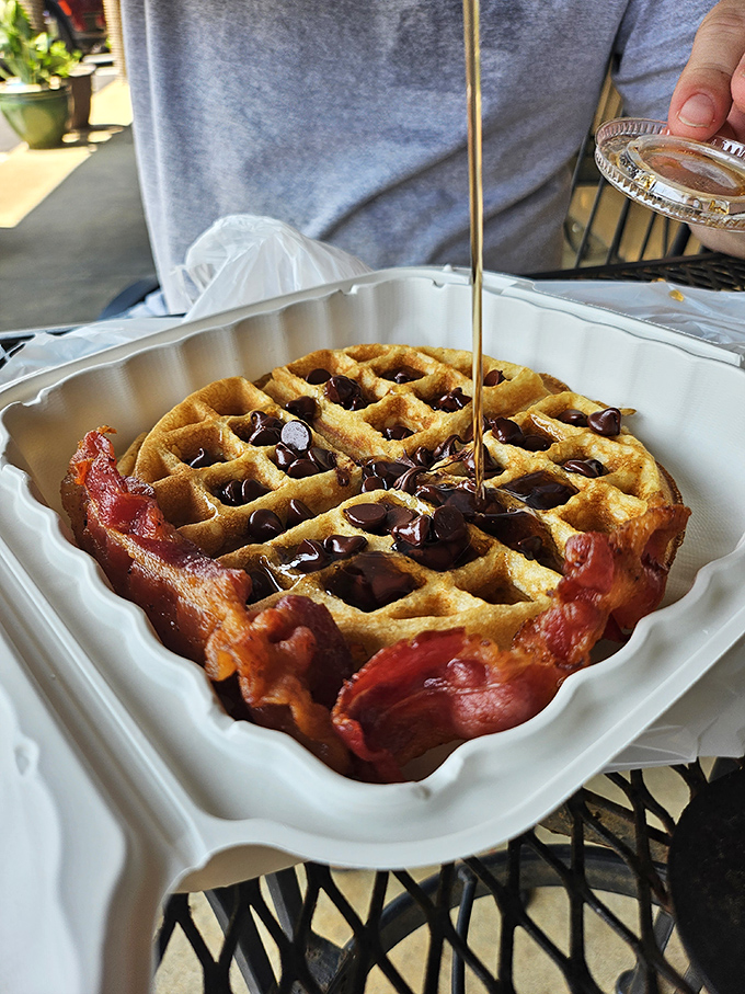 Waffle perfection achieved! This golden beauty, adorned with bacon and drizzled with syrup, is what breakfast dreams are made of.