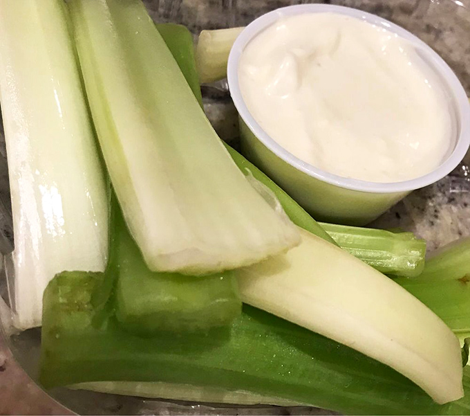 The classic wing sidekicks: Crisp celery and cool blue cheese. They're not just garnish, they're supporting actors in this flavor play.