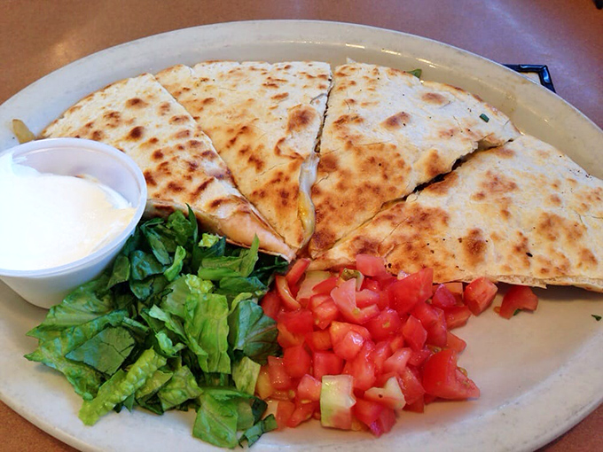 The quesadilla arrives like a crispy, cheese-filled postcard from flavor country, with fresh veggies standing by for guilt reduction.
