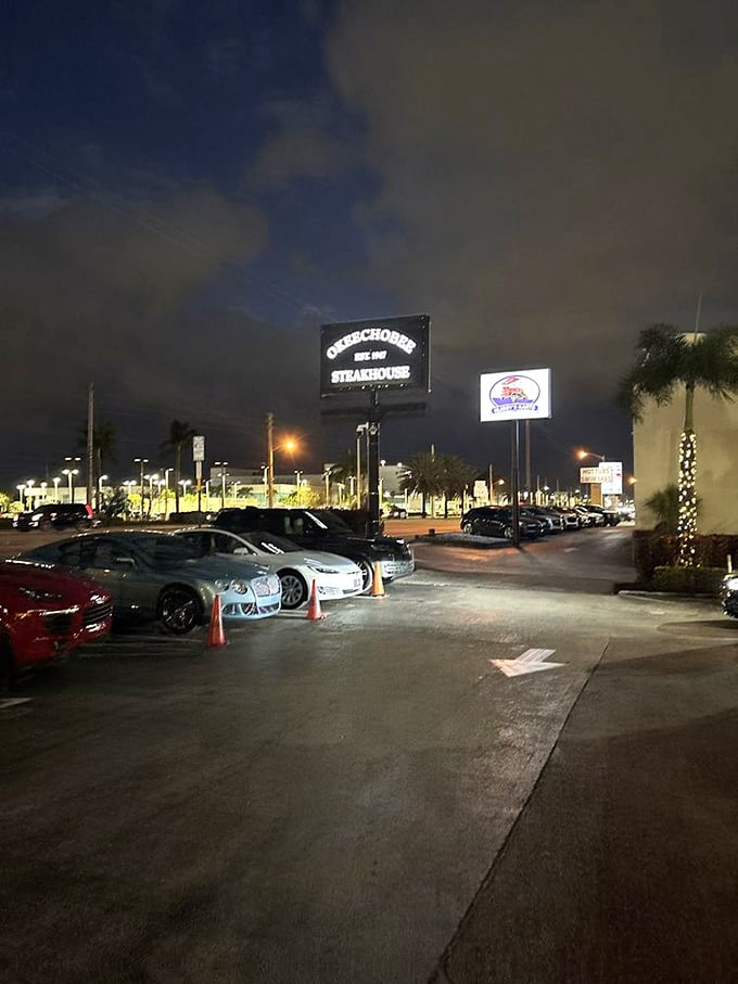 As evening falls, the illuminated sign serves as a beacon for steak lovers. The full parking lot tells you everything you need to know.
