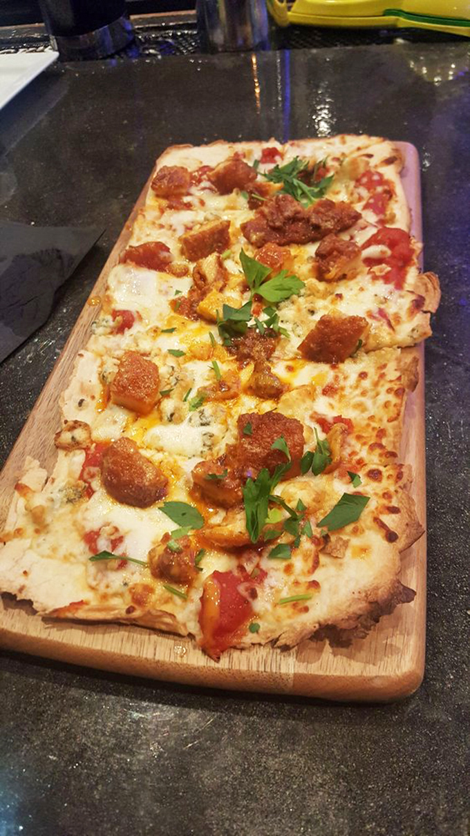 Flatbread that's anything but flat on flavor! This cheesy, herby delight proves Teak's culinary prowess extends far beyond burgers.