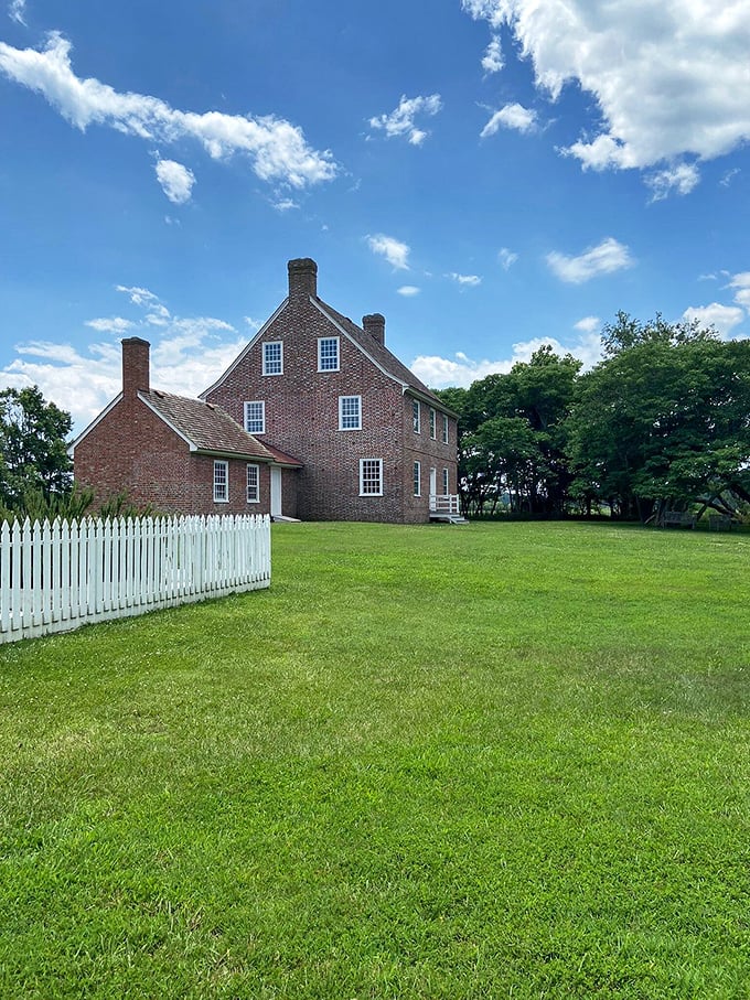 Rackliffe House stands proudly behind its white picket fence, a brick testament to colonial craftsmanship that's weathered centuries better than most of us weather a decade.