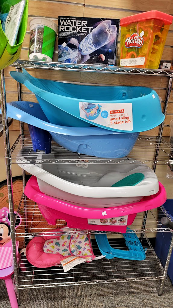 Baby bathtubs in cheerful colors stacked like nesting dolls. Proof that Thrift Store USA has life's necessities covered from cradle to recliner.