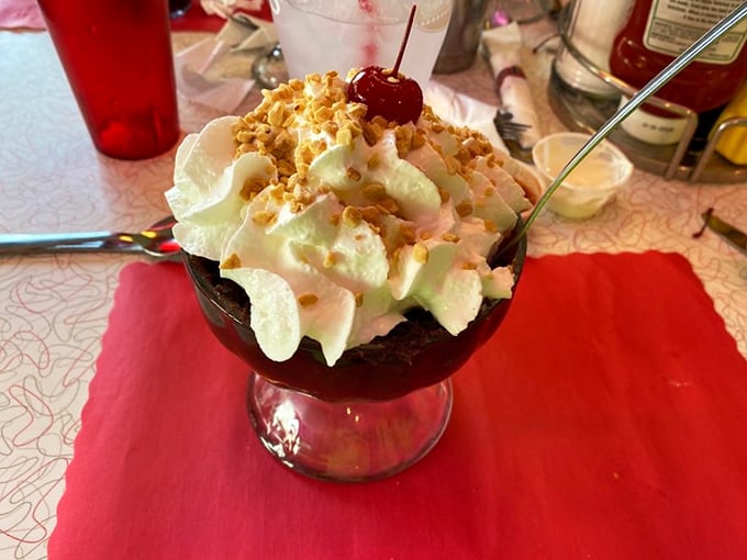 Holy hot fudge, Batman! This sundae's not just dessert; it's a tower of sweet, creamy, nutty bliss. Spoons at the ready!