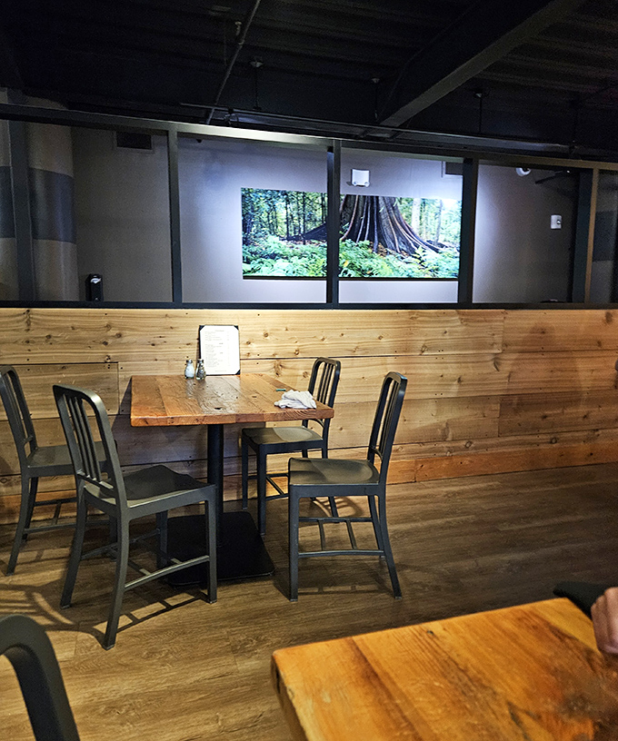 Rustic wood paneling meets nature photography in this cozy corner. It's like dining in a stylish cabin that happens to serve incredible food.