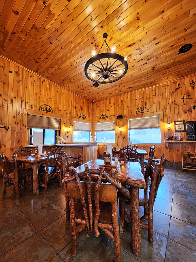 Knotty pine paradise where wagon wheel chandeliers cast a golden glow over rustic log furniture. Somewhere, Paul Bunyan is feeling very much at home.