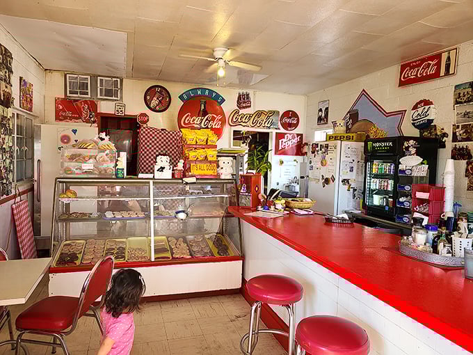 Step into a time capsule of Americana! Coca-Cola memorabilia, checkered tablecloths, and the promise of sugar-coated happiness await inside this retro wonderland.