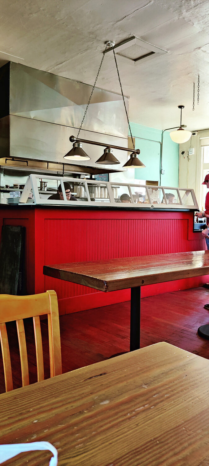 Step inside and feel the warmth! This cozy interior, with its vibrant red counter, is where pastry dreams come true.