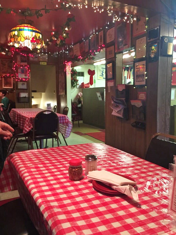 Step into a time warp of taste! This cozy interior, with its twinkling lights and checkered tablecloths, promises a pizza experience that's deliciously nostalgic.